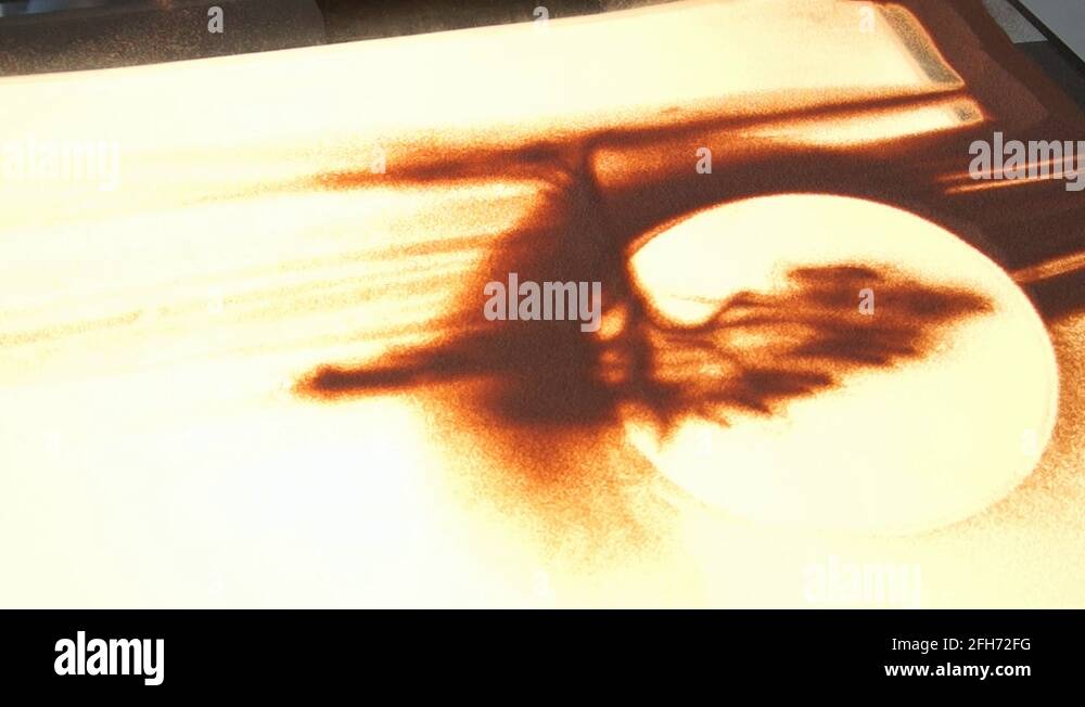 Drawing with sand. Drawing sand on a white screen. Sand Artist. Hands ...