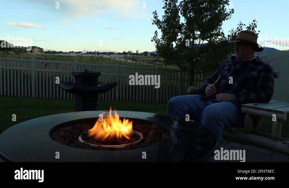 Cinemagraph of a fire pit with the flame frozen in time while a man ...
