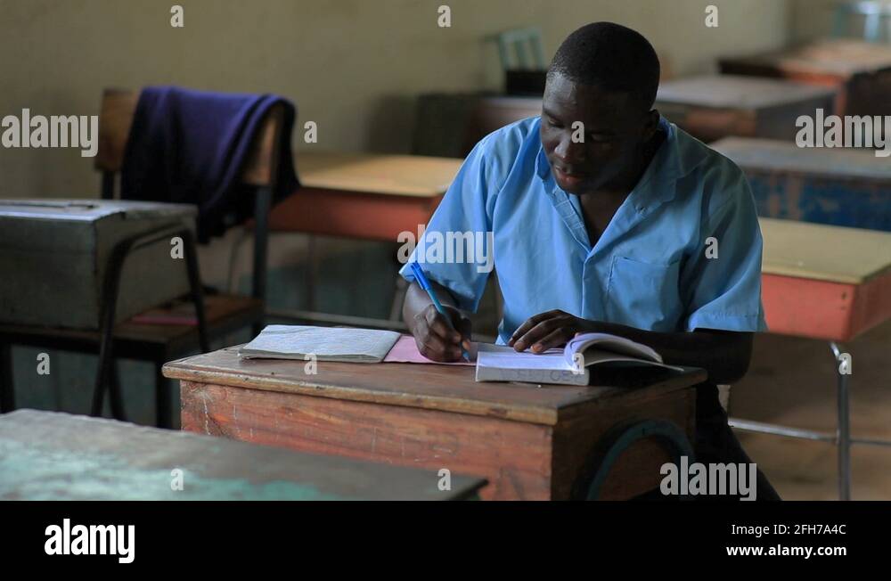 School boy doing homework in an empty classroom in a school in Kenya ...