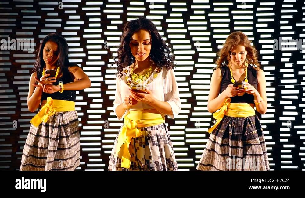 a group of women who dance and hold mobile phones, women are passionate ...