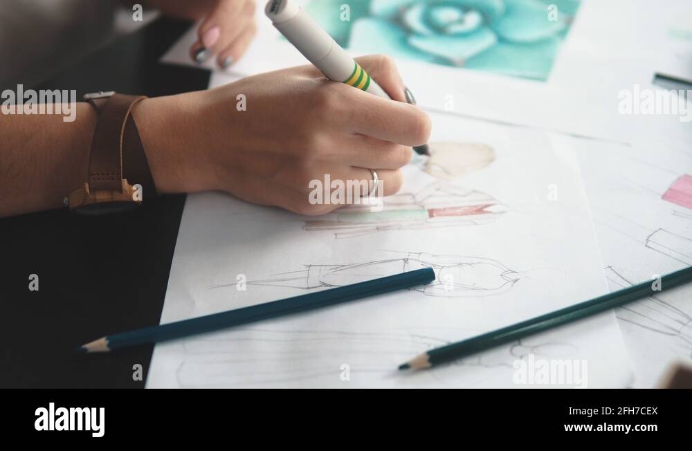 designer of clothes makes an outline of clothes with a felt-tip pen ...