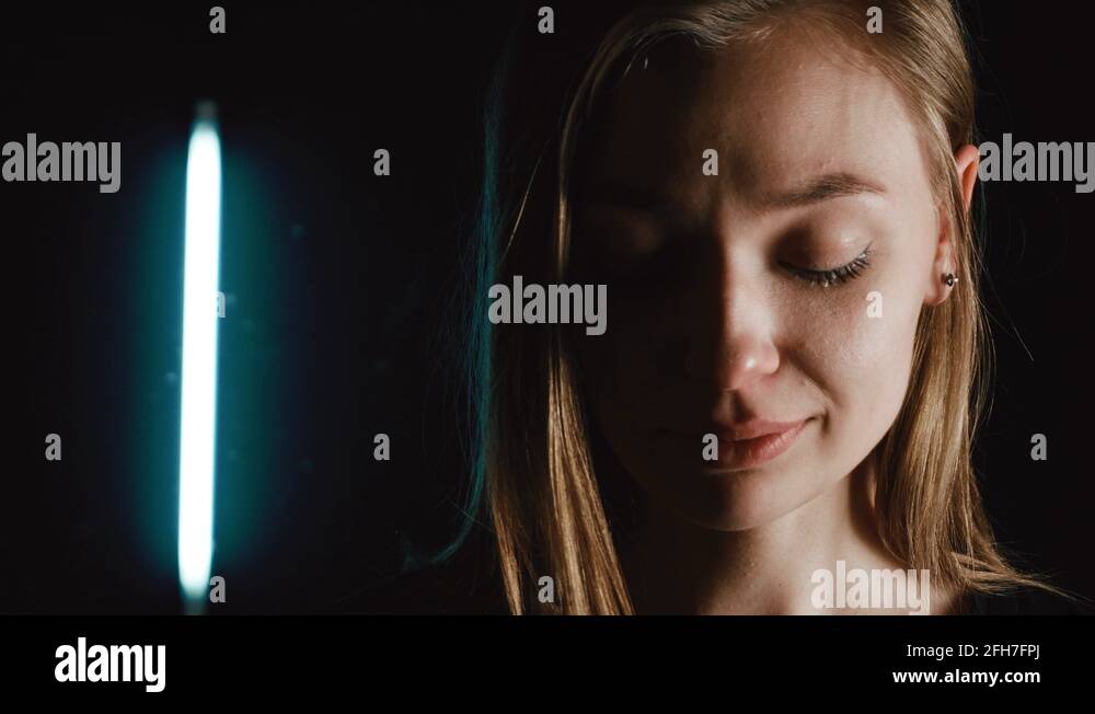 A woman is crying in the dark. She is very sad. Tears flow down her ...