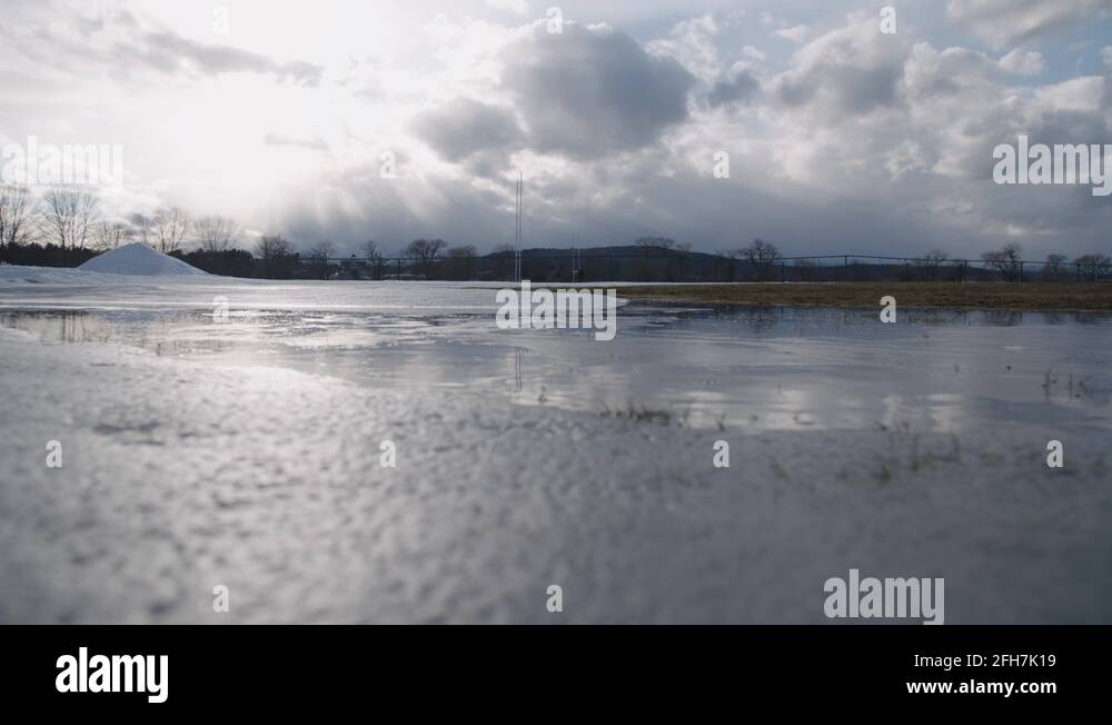 Reflection in Water Puddle and Snow with Football Field in Far ...