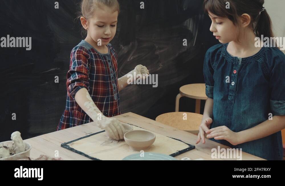 lesson on clay modeling. two little girls little sister are engaged in ...