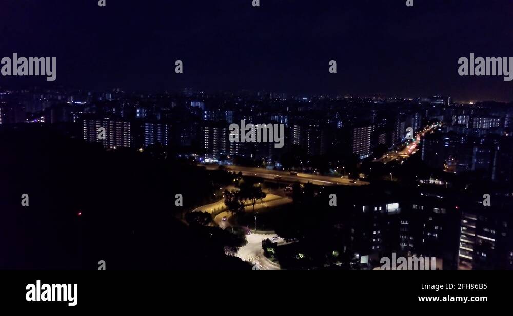 Dark Singapore city landscape. HDB apartments lit up at night busy ...