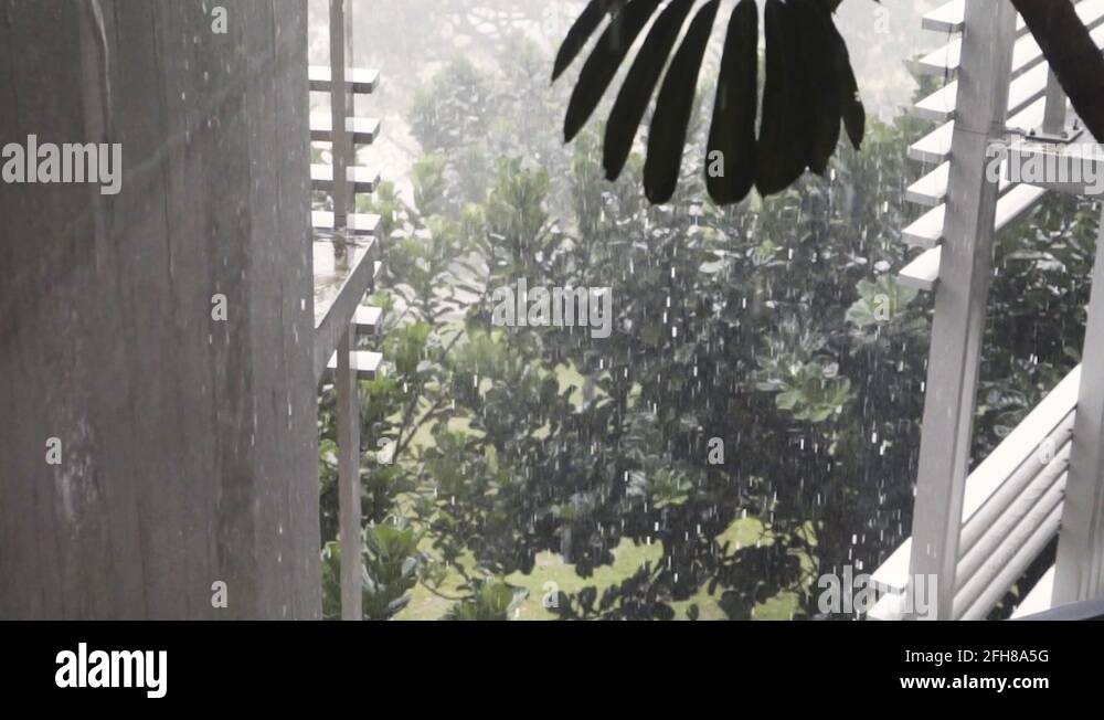 Beautiful Slow motion rain fall from window of a concrete building ...