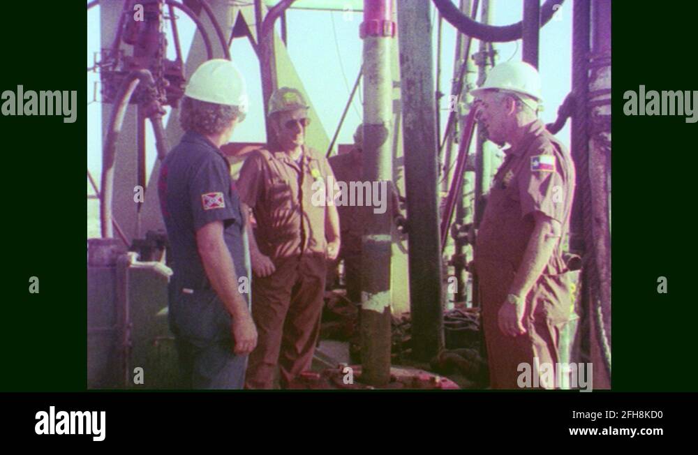 1970s: Three workers stand and talk around the drill pipe on top of the ...