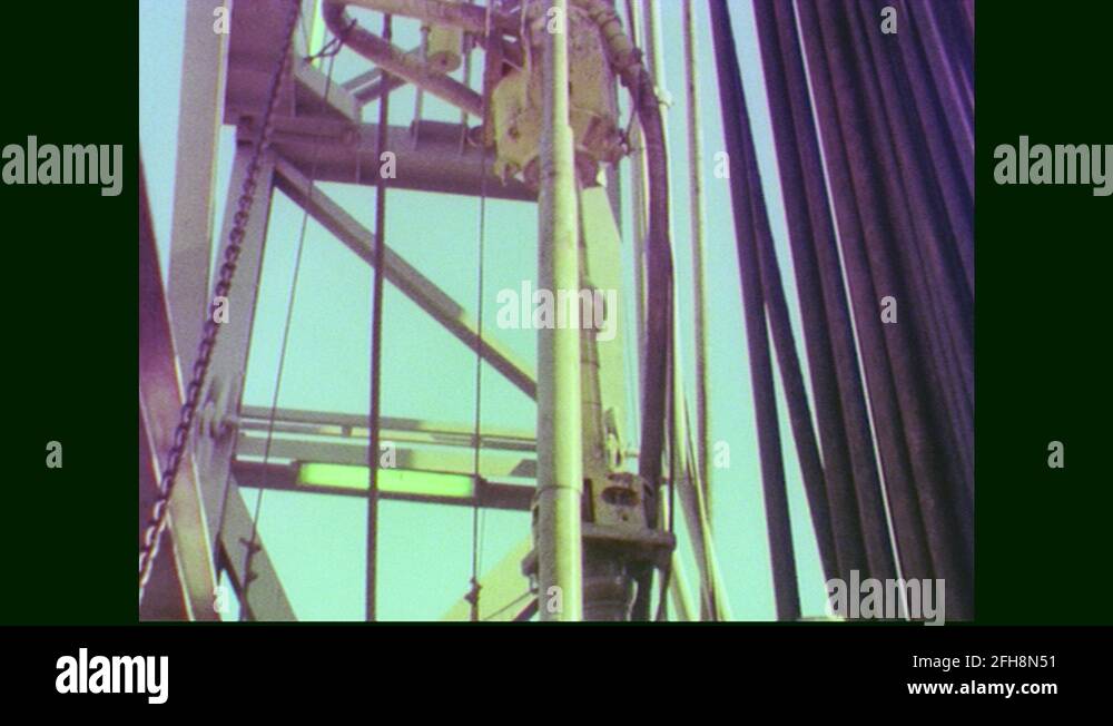 1970s: Drill pipe and coupling lowers through the hole in the oil rig ...