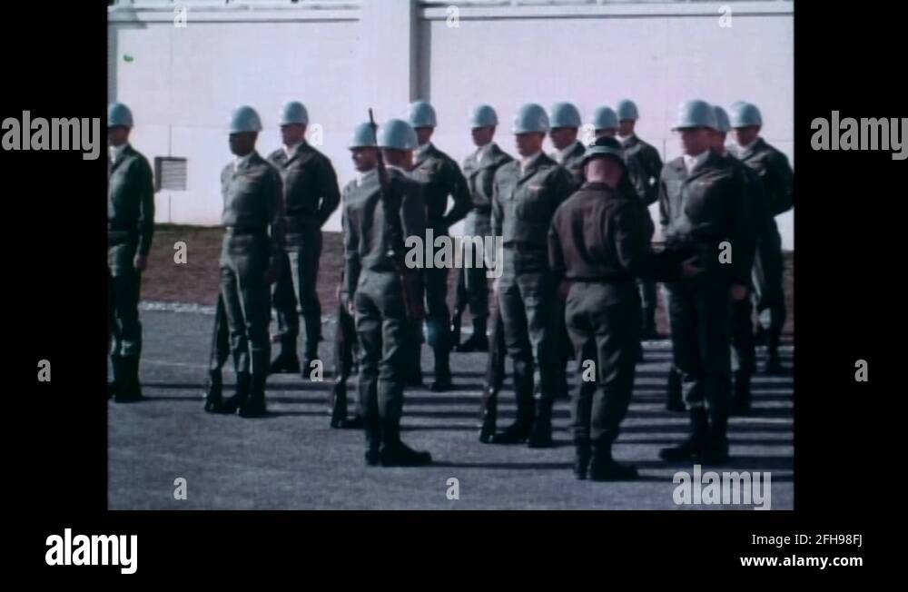 Senior officer checks the rifle of cadets, graduation day in auditorium ...