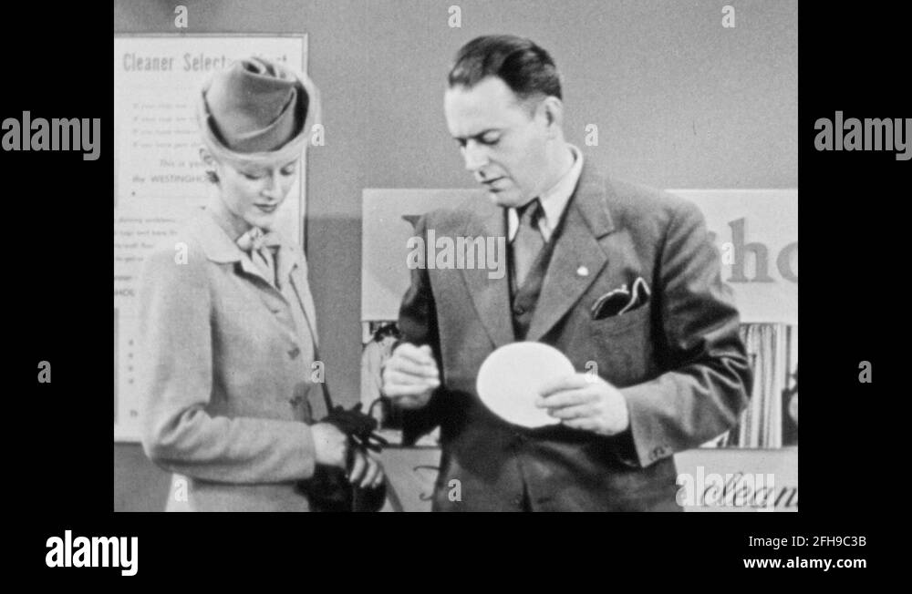 1940s: Salesman and customer talk. Salesman shows woman clean filter ...
