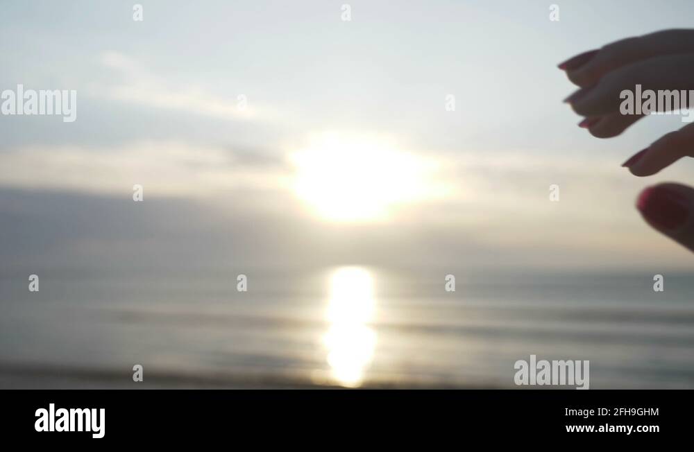 Couple making heart shape with their hands with sunset inside on the ...