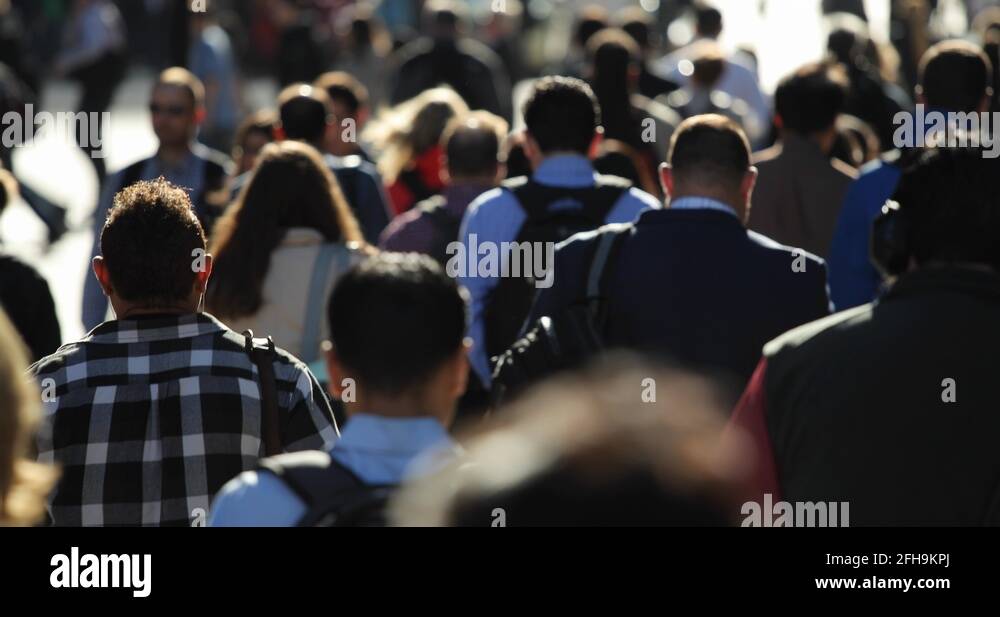 Crowd of commuter people walking street to work backlit silhouette slow ...