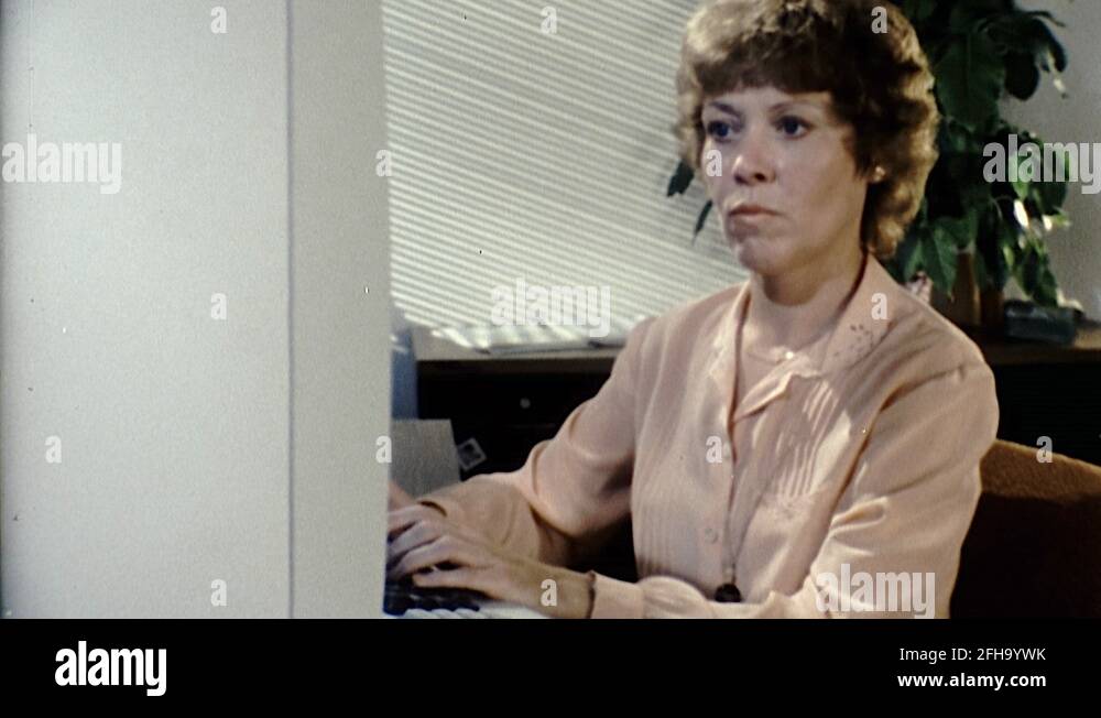 1980s Woman at Retro Computer Uses Mouse Looks Monitor Vintage Old Film ...