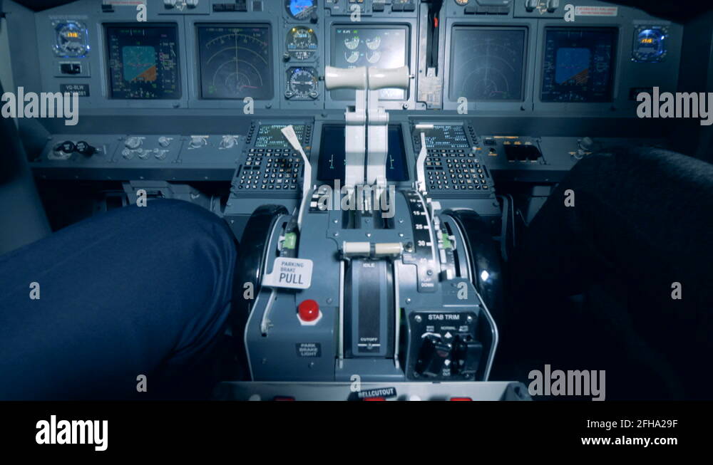 Two men are sitting in a cockpit of a flight simulator and are ...