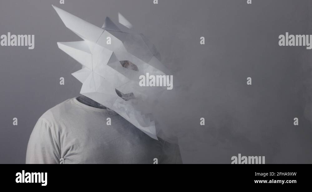 CINEMAGRAPH - Male wearing dragon head paper craft mask exhaling smoke ...