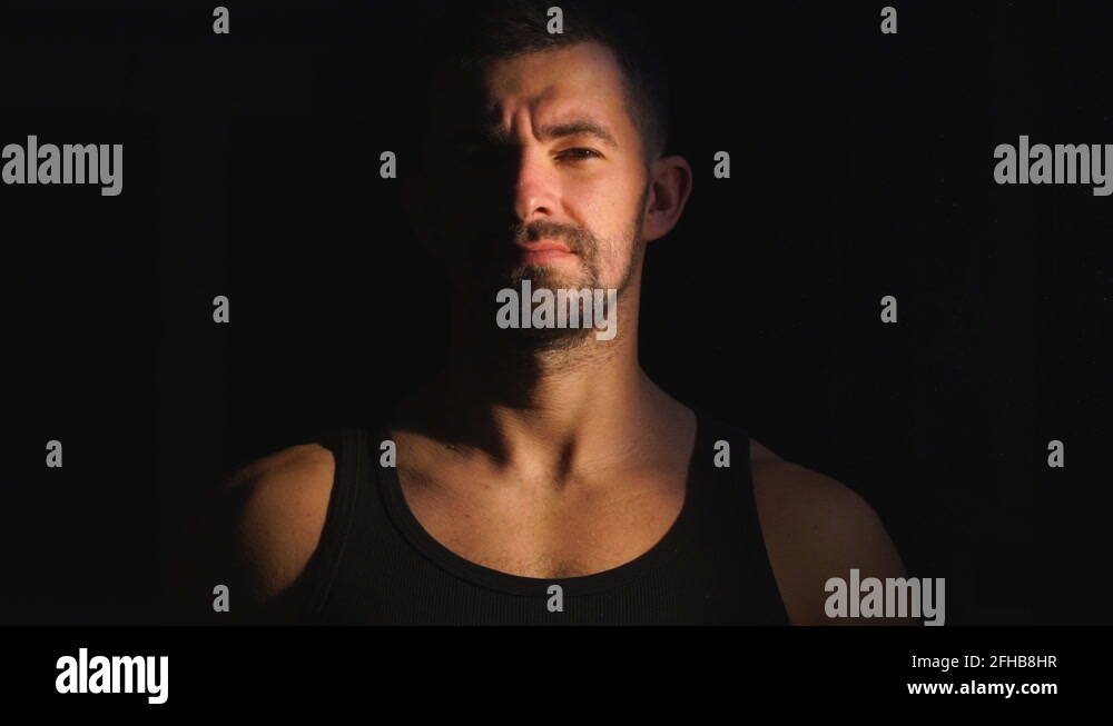 strong muscular bearded bodybuilder clapping hands with chalk powder ...