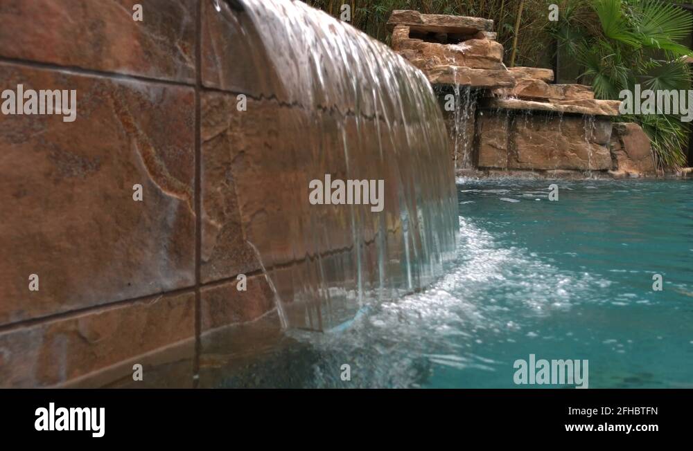 Pool Hot tub with water spilling into pool and a full waterfall feature ...