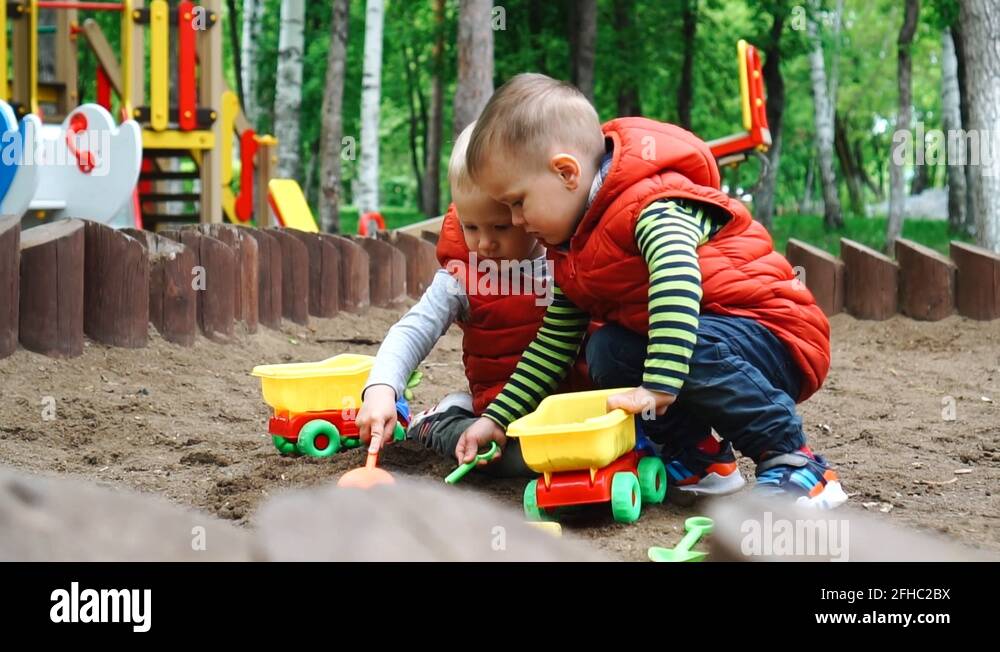 Two children playing in sandbox Stock Video Footage - Alamy