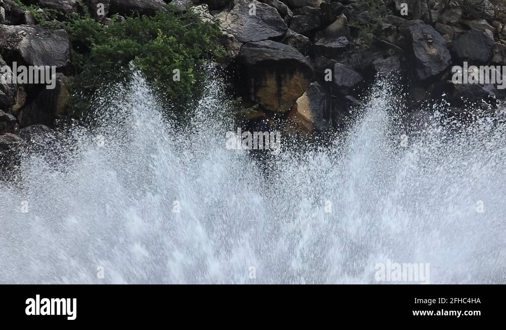 Water cascades down a man made dam in a rural region Stock Video ...