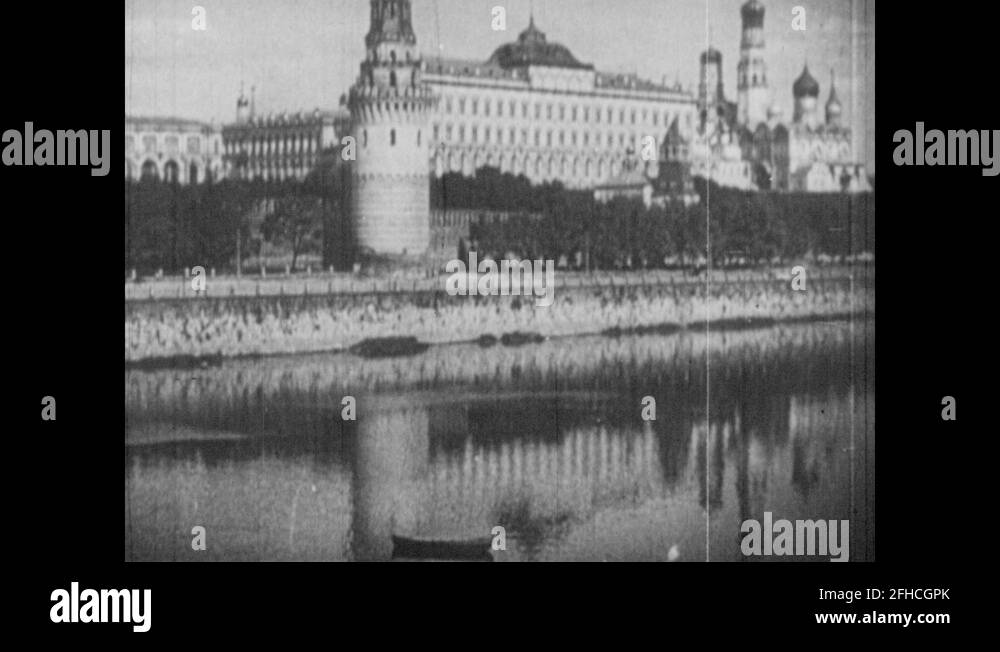 1930s: Large building. Crowd of men stand and applaud. Stalin waves ...