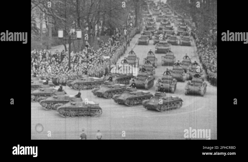 1930s: Tanks, military vehicles parade down street, Nazi flag flies ...