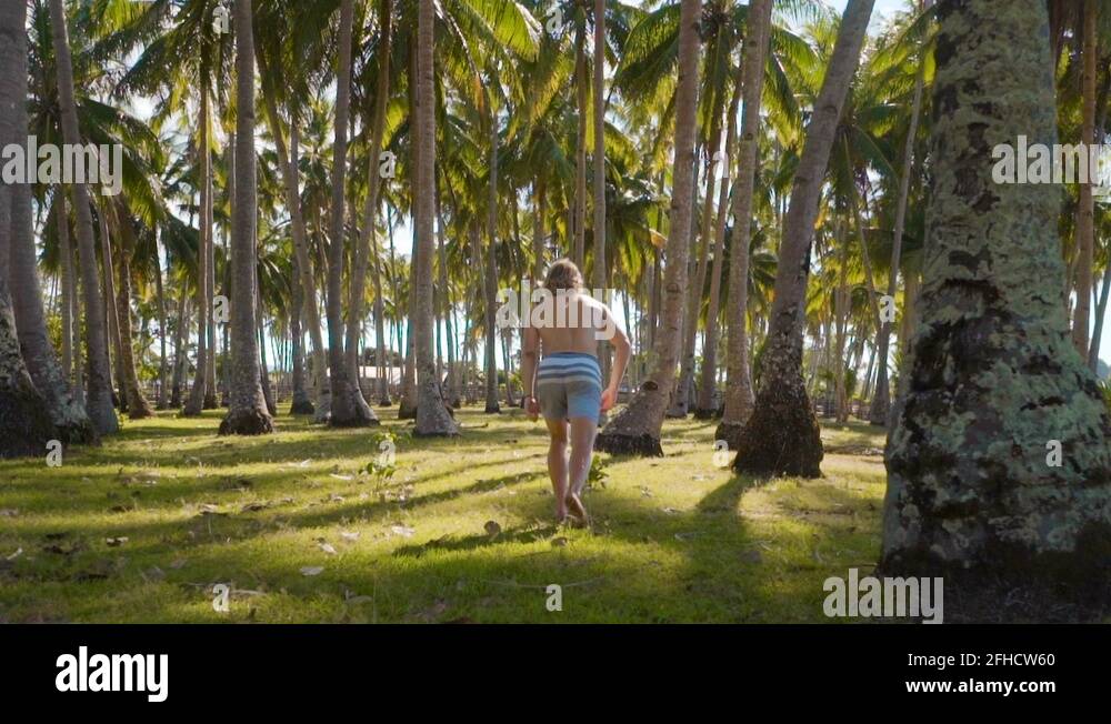 Man running through field of palm trees in slow motion. El Nido ...