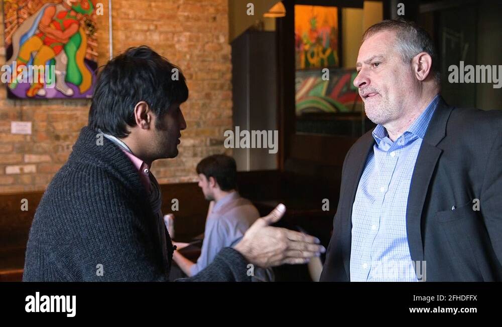 Two men have an animated discussion at a crowded bar in Chicago, early ...
