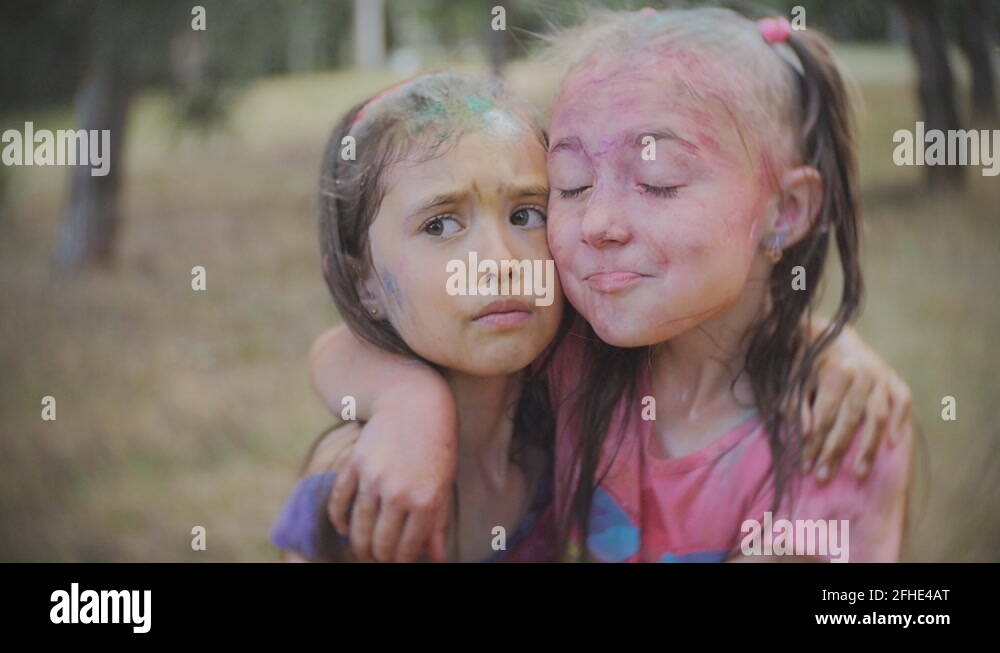 Two little girls smeared with colored powder Holi sprinkle water Stock ...