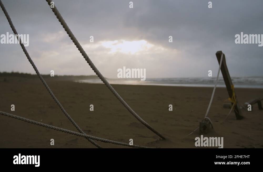 Abandoned wreck and rope buried in sand on remote beach with heavenly ...
