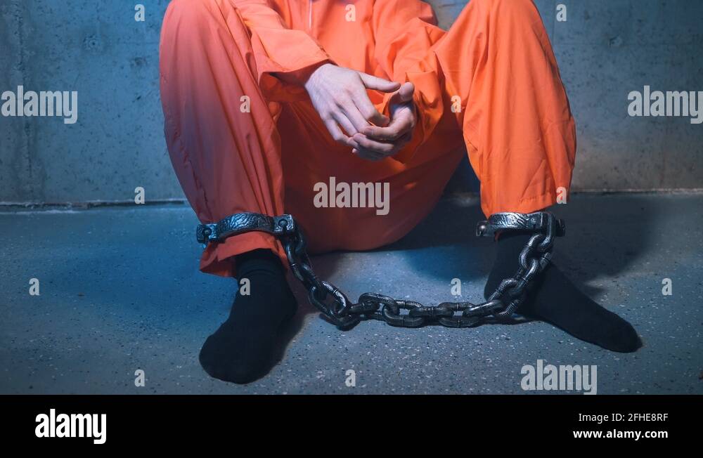 Prison Inmate Sitting in His Cell With Chains Around His Feet Stock ...