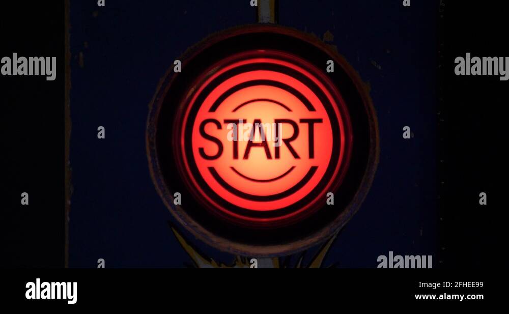 Close up of hand pushing the red lit up start button on a vintage ...
