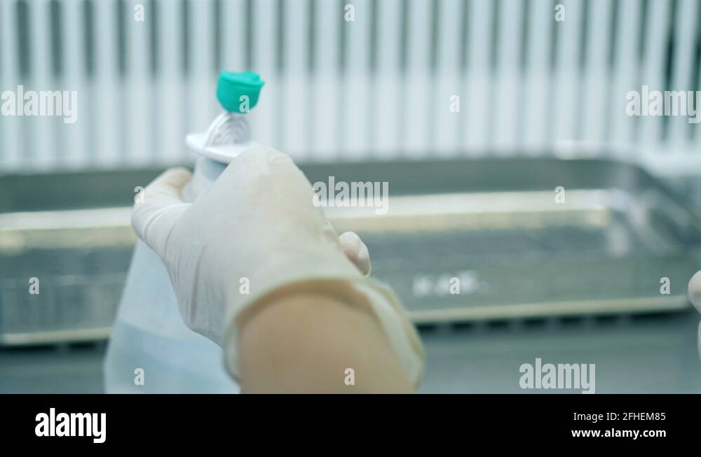 Doctor picking up medication into a syringe and prepares it for ...