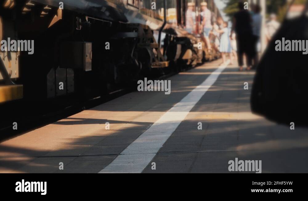 Departure of the train from the platform, hurrying passengers go on the ...