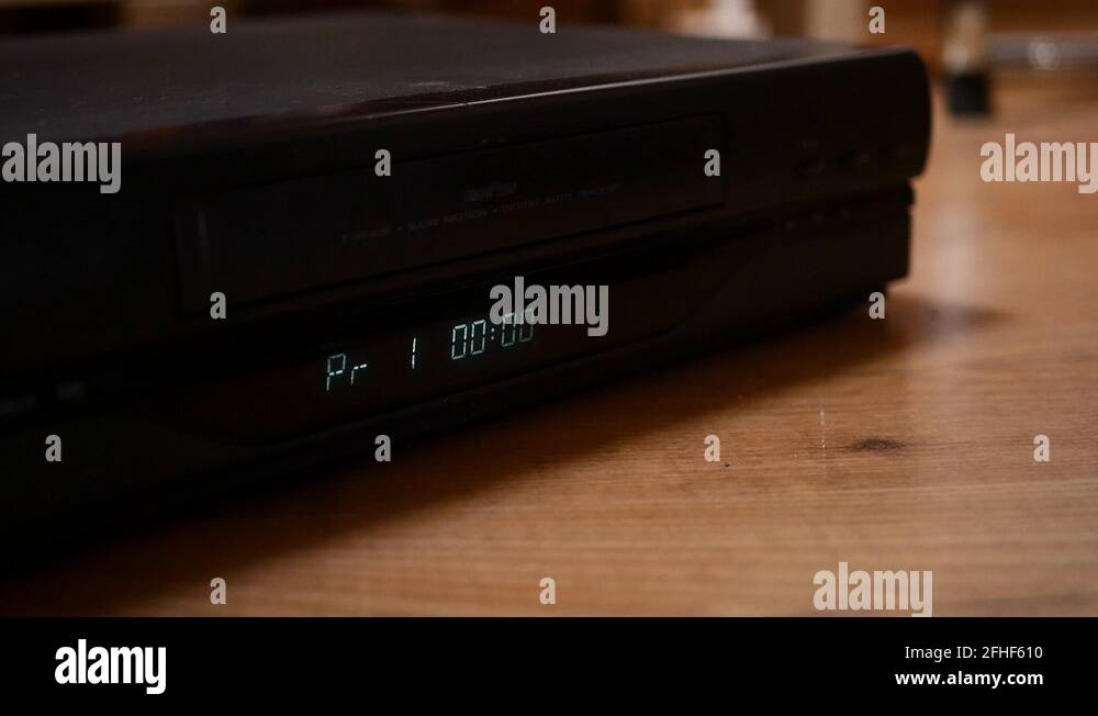 a hand puts an old vhs tape into the vhs recorder/player Stock Video ...