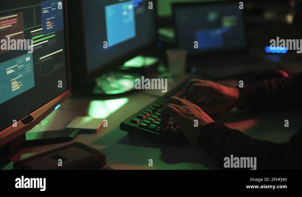 Hacker With Hoodie Working With Multiple Screens And Hacking Systems