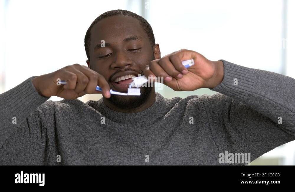 African american black man squeezing toothpaste on a toothbrush Stock ...