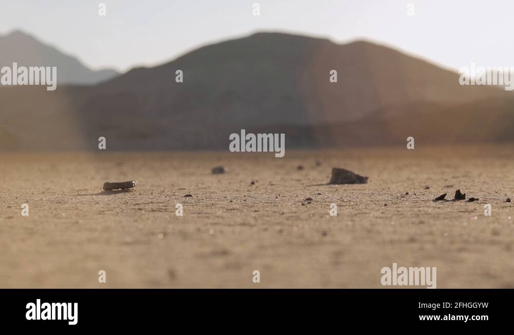 Rocks and pebbles on desert floor in front of hills in Death Valley ...