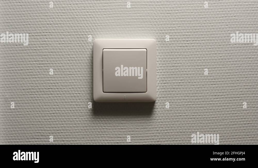 Human hand fast turn off a power button on a light-grey wall - Front ...
