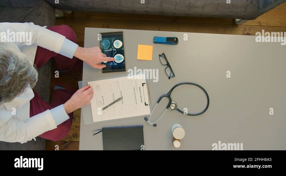 Overhead Of Doctor Analyzing Brain CT Scan While Filling Medical Form ...