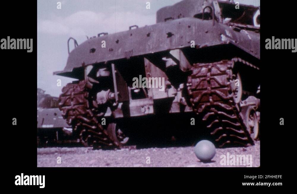 1960s: Orange and blue ball roll and explore an abandoned military tank ...