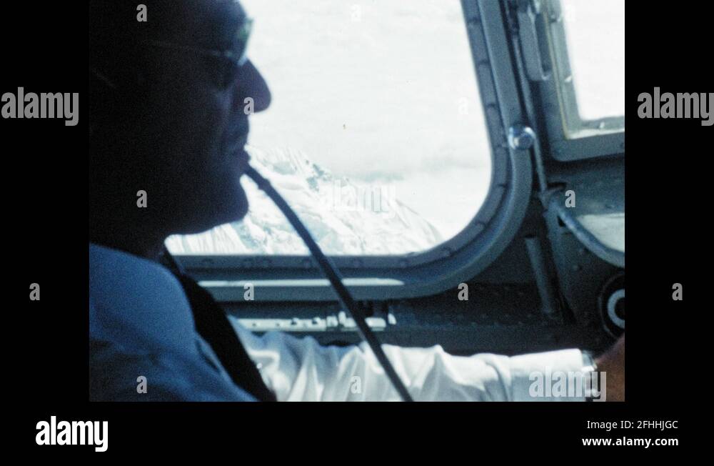 1950s: Pilot flies plane. Plane flies over mountains. Cockpit of plane ...