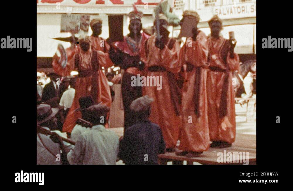 1950s: Performers in costumes dance on stage. Woman sits on top of ...
