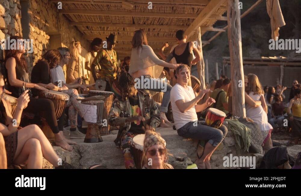 People playing the Bongo Drum at Benirras beach in Ibiza spain. This is ...