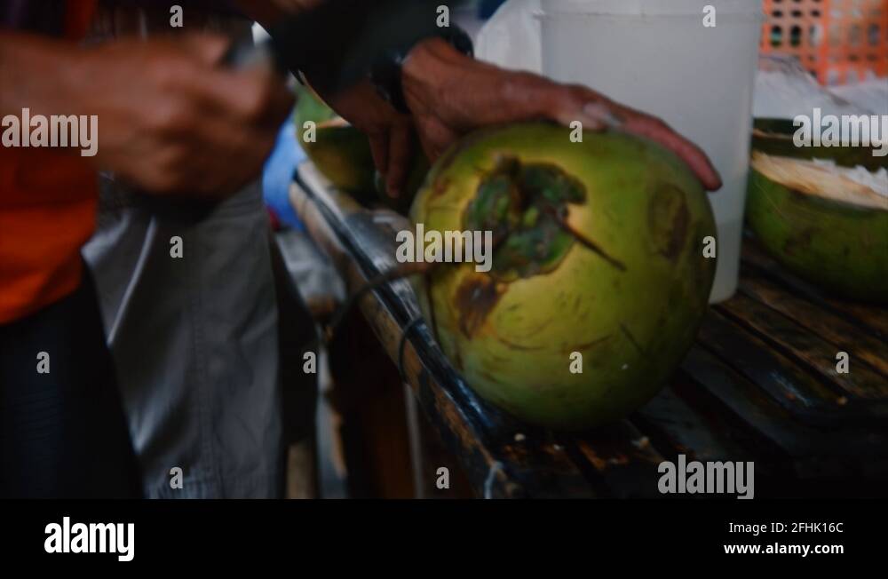 A coconut vendor choose a coconut to open it to make a buko/coconut ...