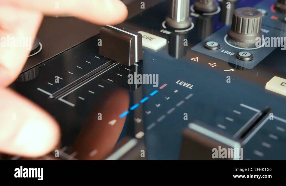 DJ adjusting the volume on mixing console at edm music festival Stock ...