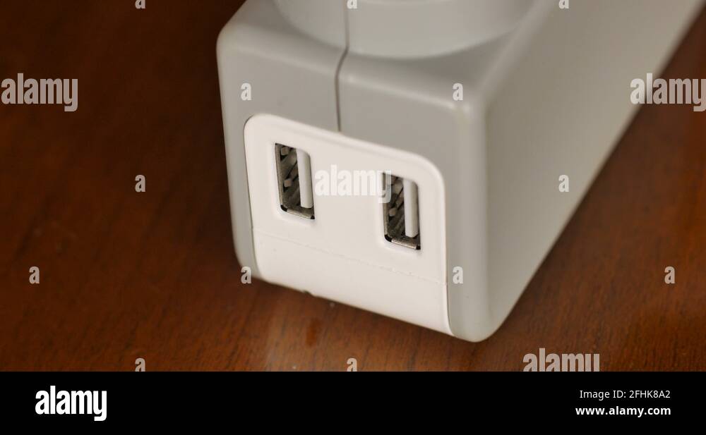 Hand plugging in a USB Type A cord into an adapter or hub - close up ...