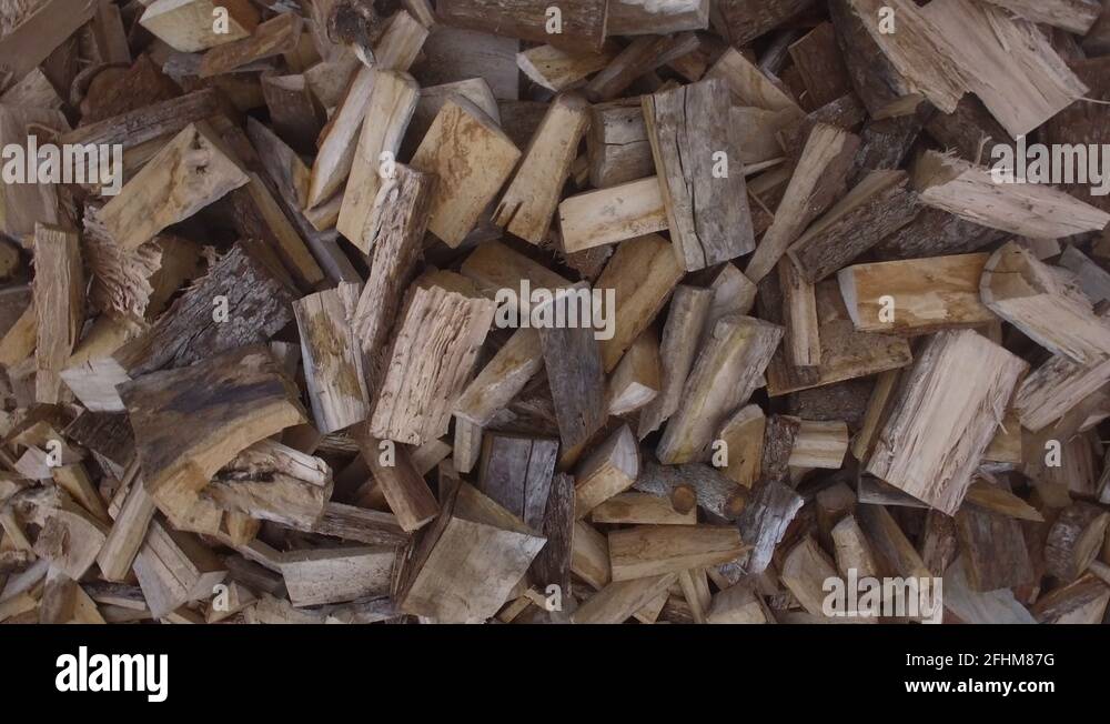 A birds-eye aerial of a wood chopping yard. A wood pile and tractor ...