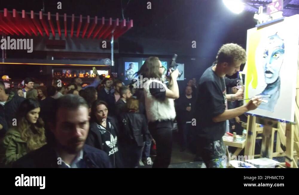Artist Painting In Front Of Crowd In Dark Art Gallery - Pan - Right To ...