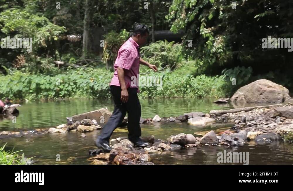 Man Walking Over Rocks And Fixing His Hair With River Water - Static ...