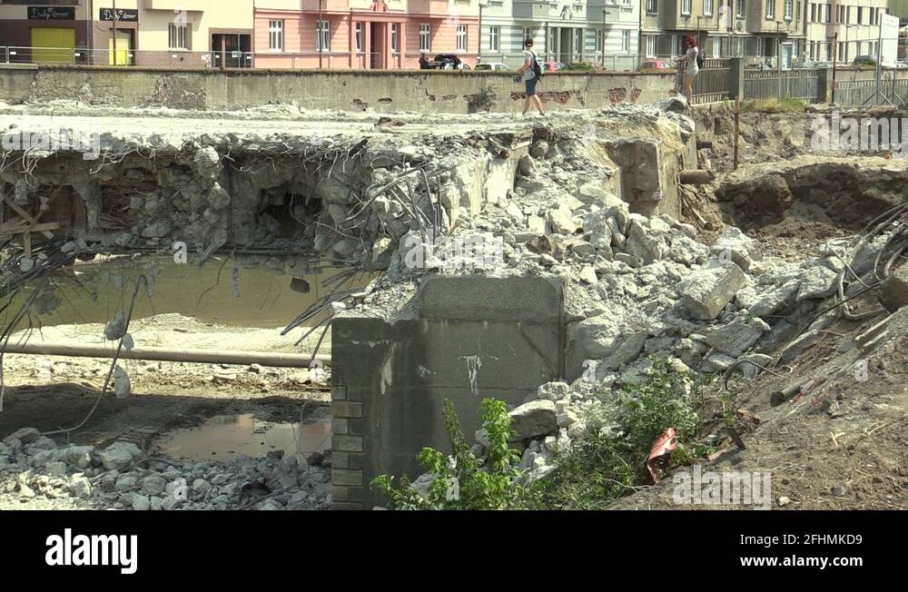 Demolition of a concrete and iron steel old bridge which people walking ...